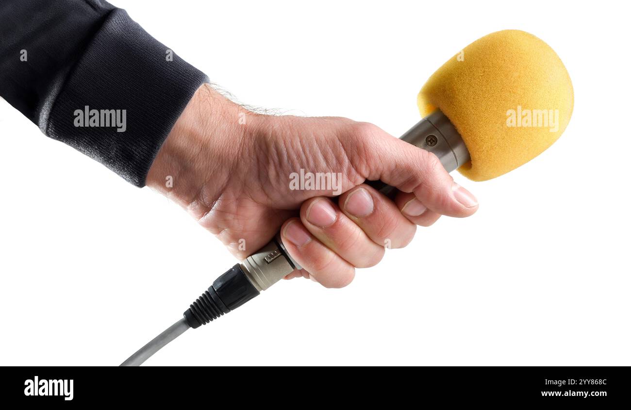 Hand in grey sweater holding metal handheld microphone with yellow foam ...