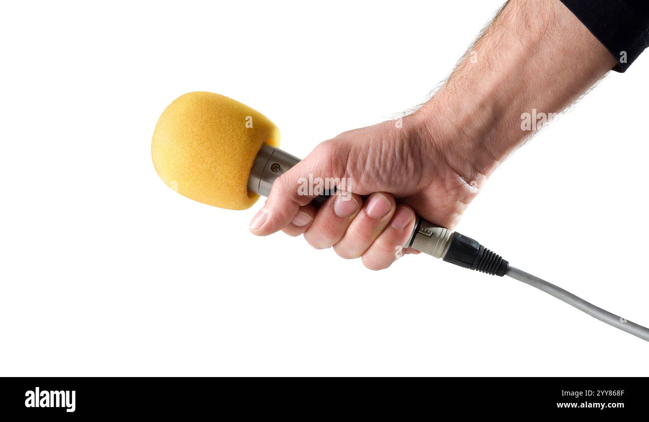 Hand in grey sweater holding metal handheld microphone with yellow foam ...