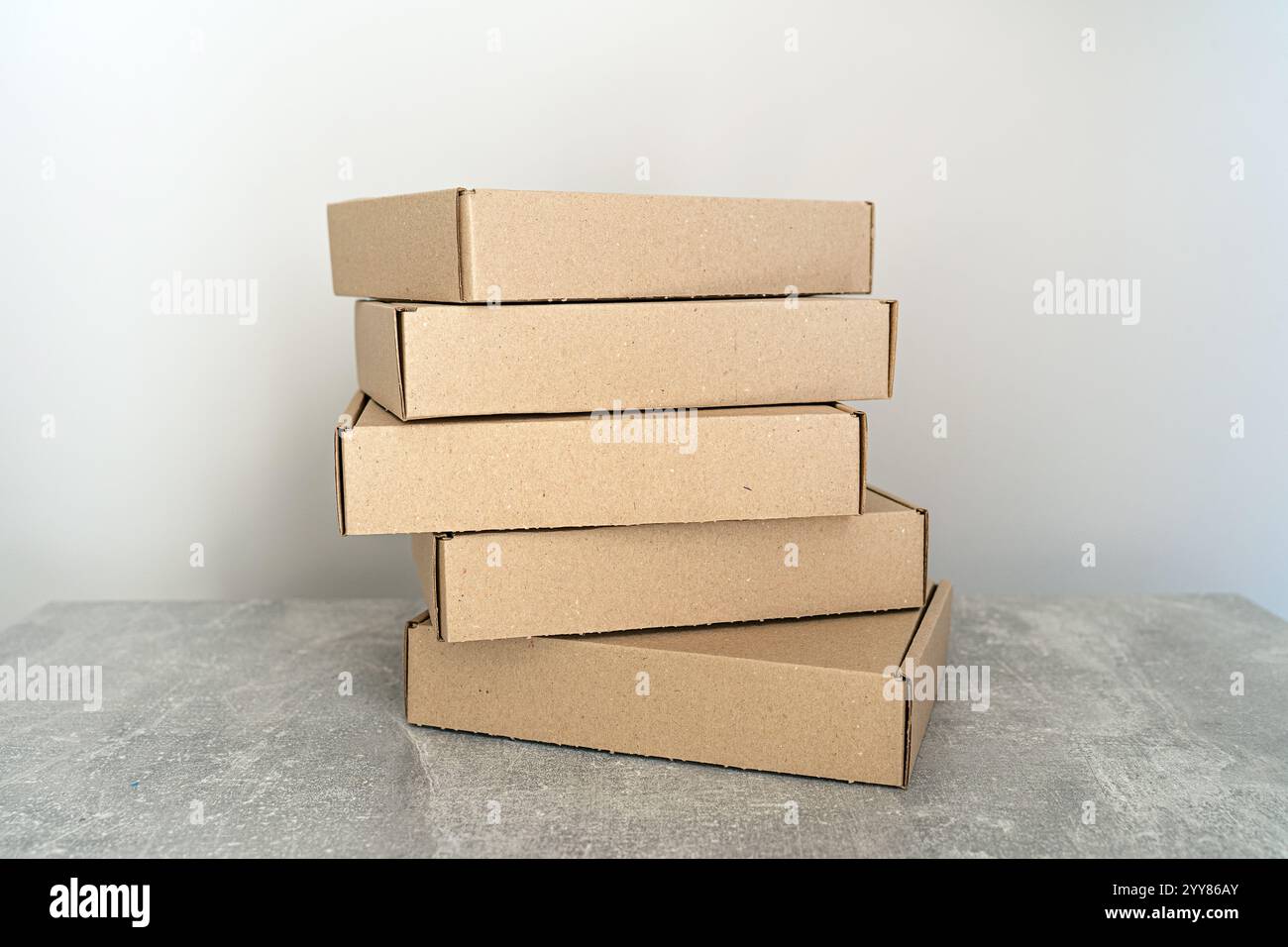 A stack of self-assembly kraft cardboard boxes arranged on a textured ...