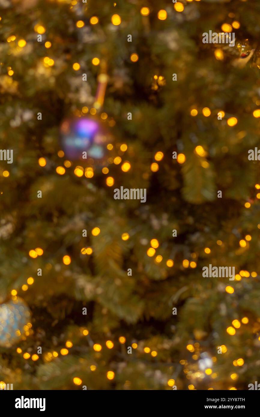 Yellow lights of a festive electric garland shine among the green ...