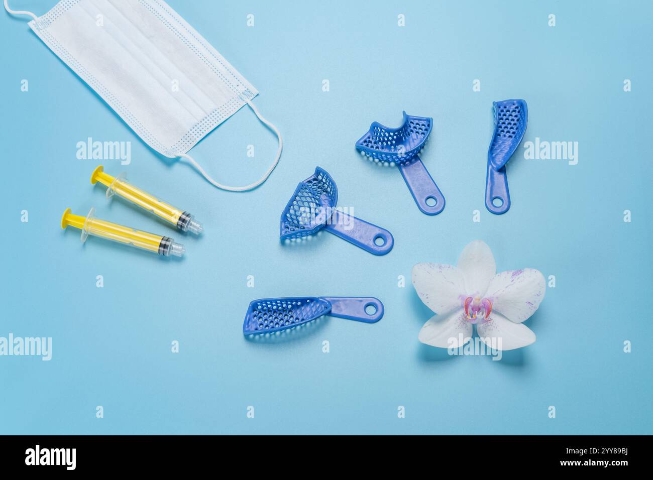 Set of dental flexible impression trays with plastic syringes and a ...