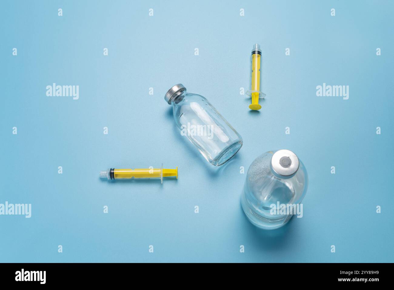 Glass bottles of liquid medicine and plastic syringes for injection on ...