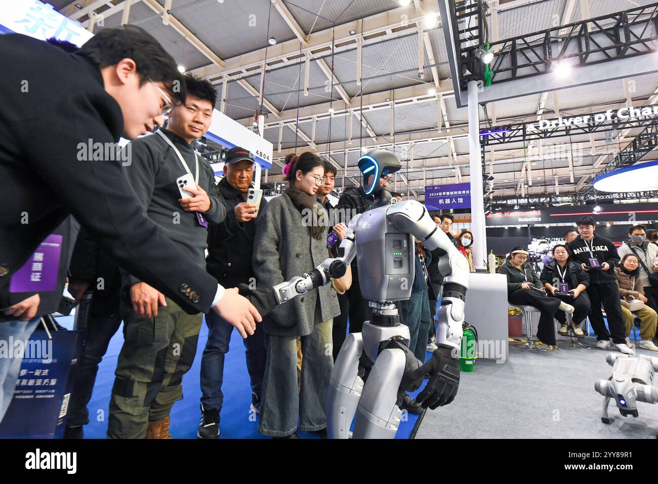 NANJING, CHINA - DECEMBER 20, 2024 - People shake hands with humanoid ...