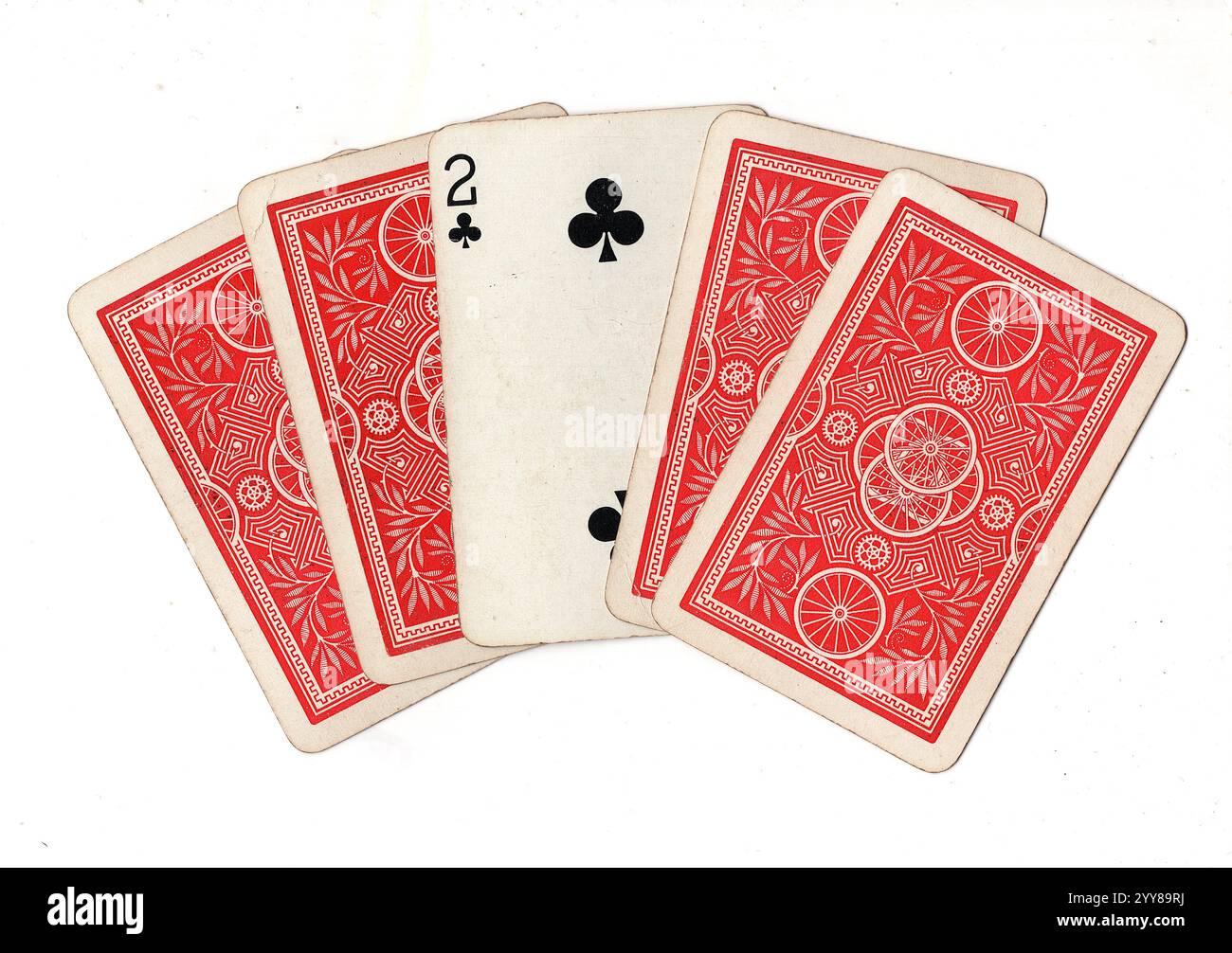 A hand of vintage playing card backs with the two of clubs revealed on ...