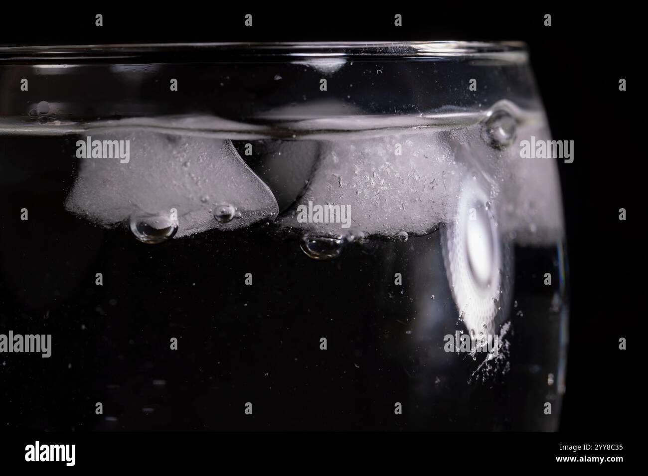 glass with cold sparkling water close up, cold mineral water with a lot of gases and bubbles ...