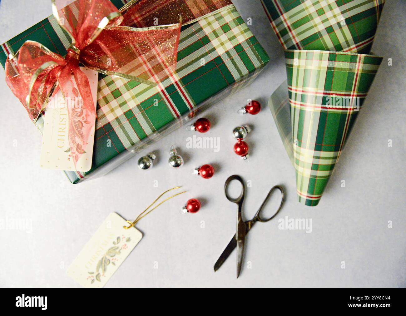 Christmas gift wrapping scene with plaid paper, red ribbon, and Stock ...