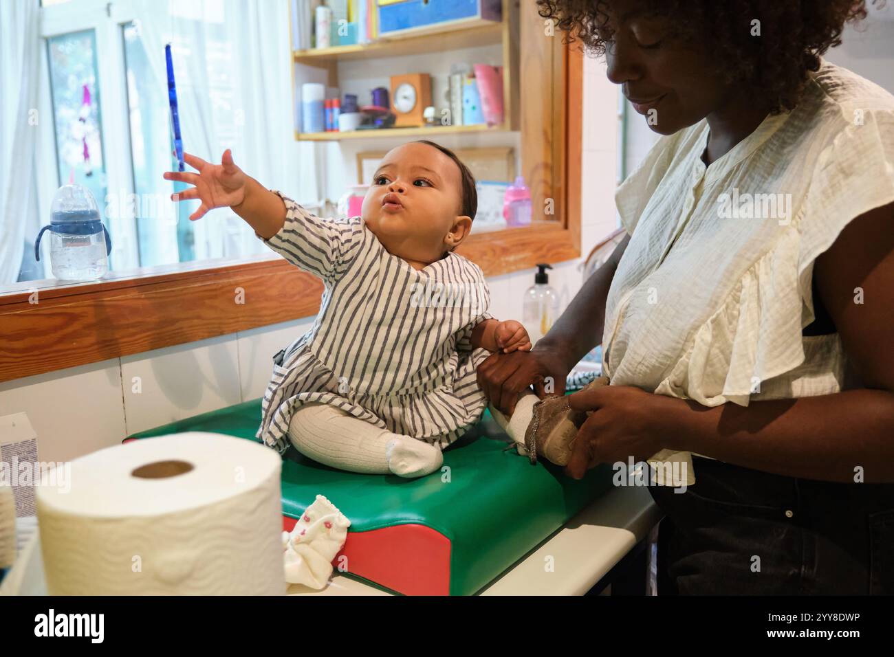 Mother dressing her baby girl on changing mat at home Stock Photo - Alamy