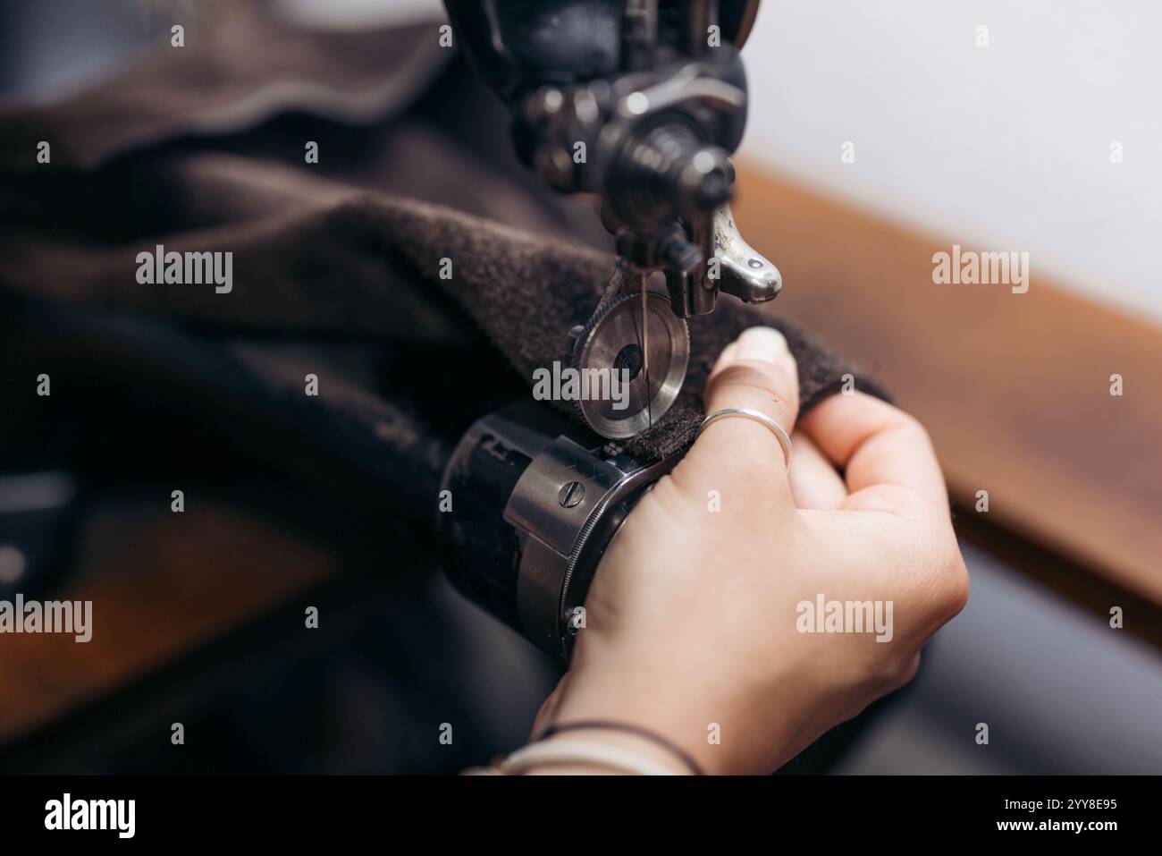 Leather artisan stitching material using vintage sewing machine Stock ...