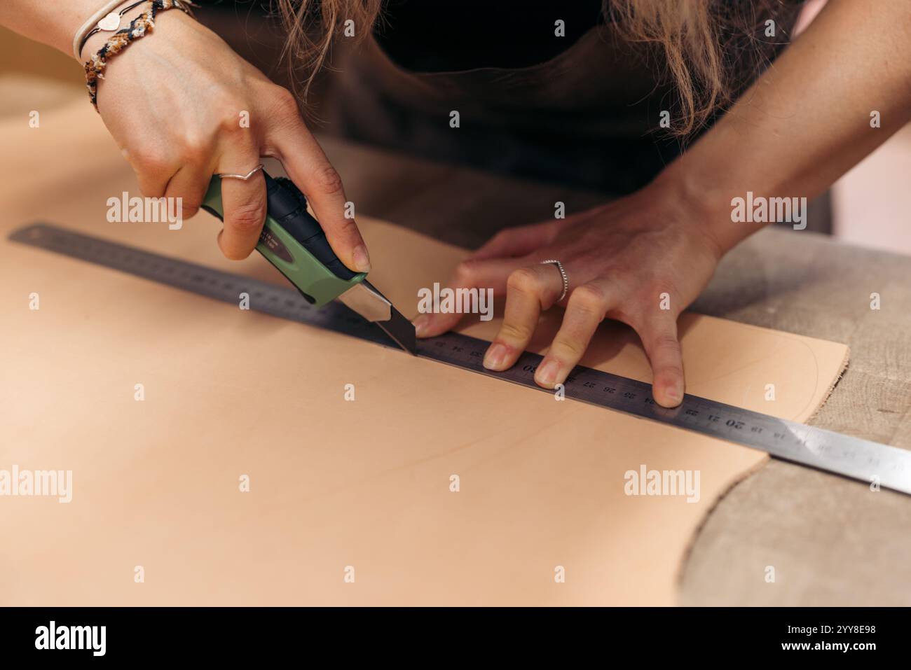 Cutting leather material with precision for handcrafted tailoring Stock Photo - Alamy