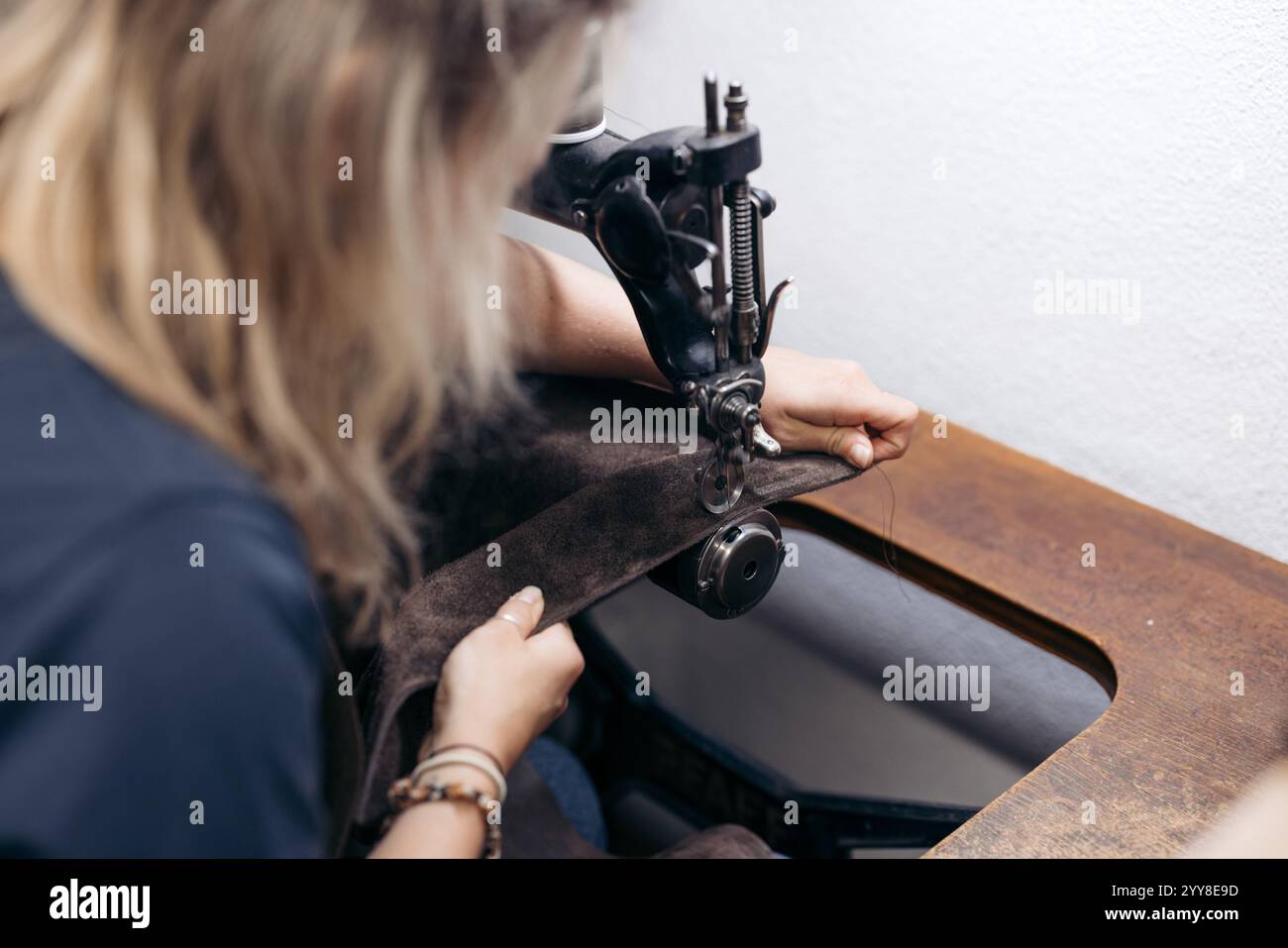 Leather artisan stitching material using vintage sewing machine Stock ...