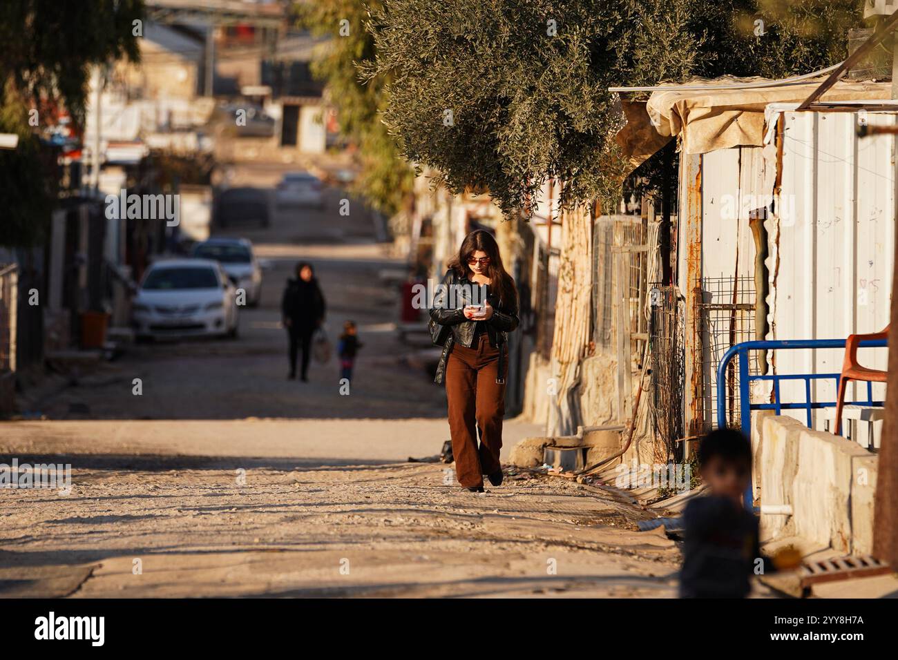 A young woman walks on the street at Domiz camp for Syrian Kurdish ...