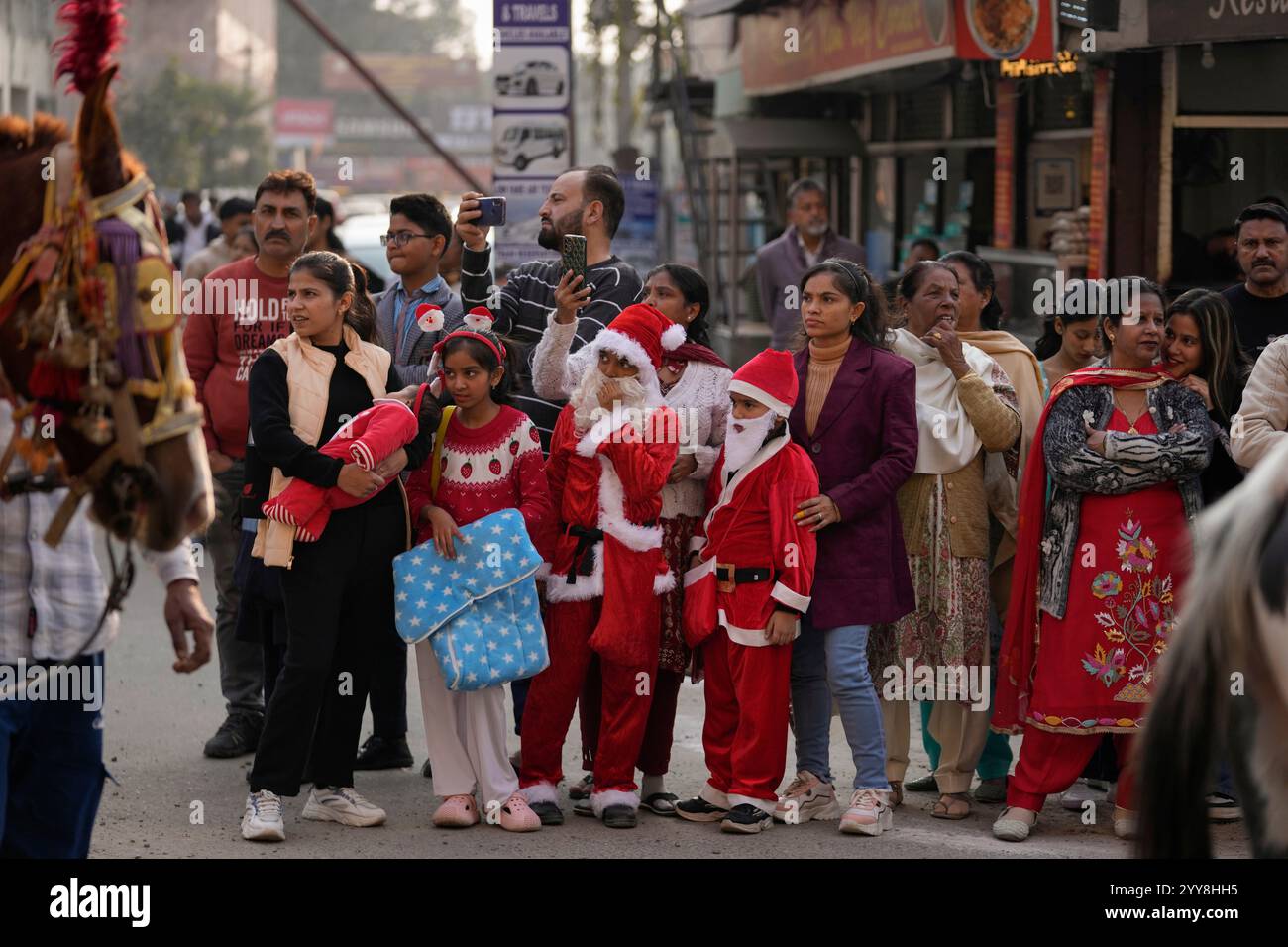 Indians watch a Christmas procession in Jammu, India, Friday, Dec. 20 ...