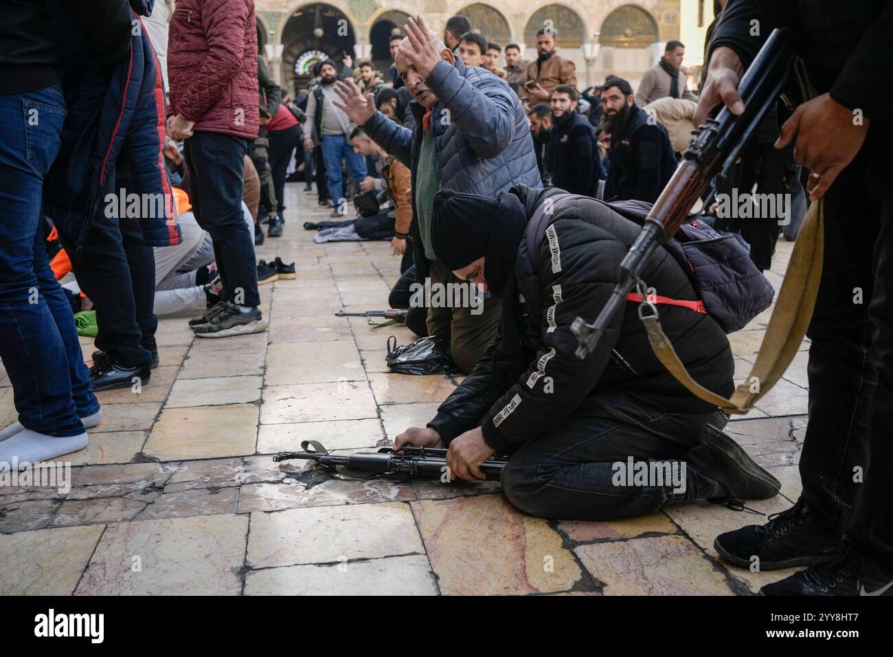 Syrian fighters place their weapons on the floor before Friday prayers ...
