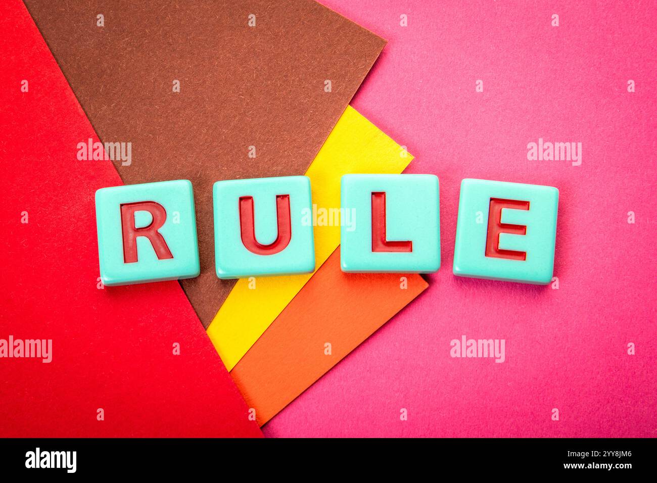 RULE. Alphabet letter tiles on a red textured background Stock Photo ...