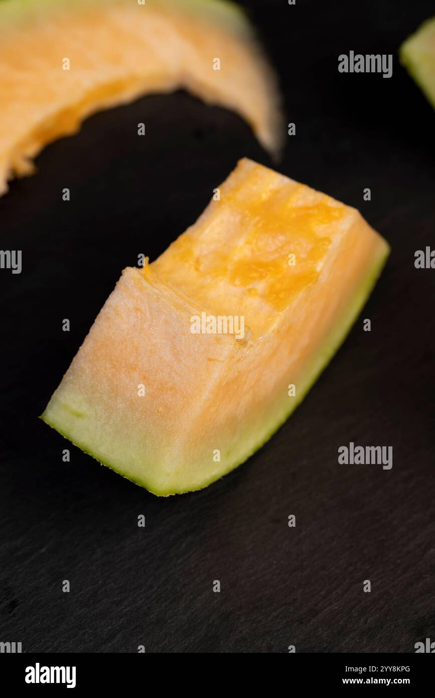 melon cut into pieces close up, slicing sweet orange melon into pieces ...