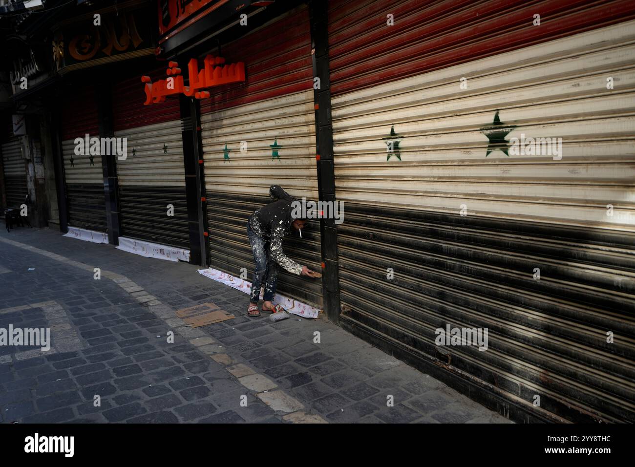 A worker removes from door shops the colours of the official flag of ...