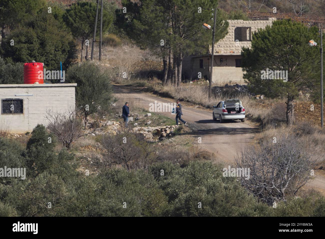 Civilians stand next to a house on the buffer zone near the so-called ...