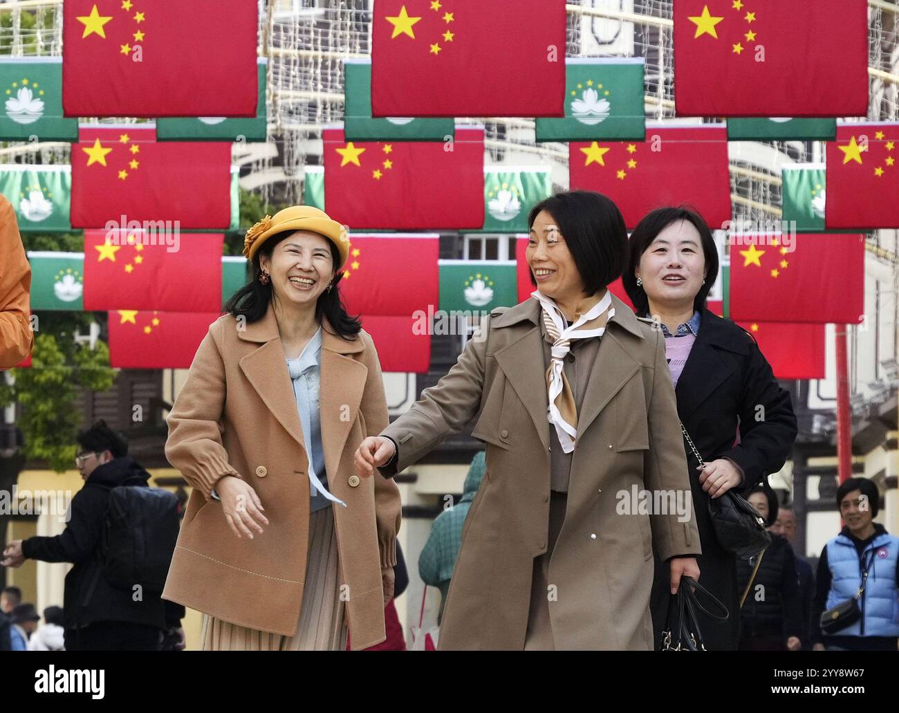 The flags of China and Macao can be seen as people walk in Macao on Dec ...