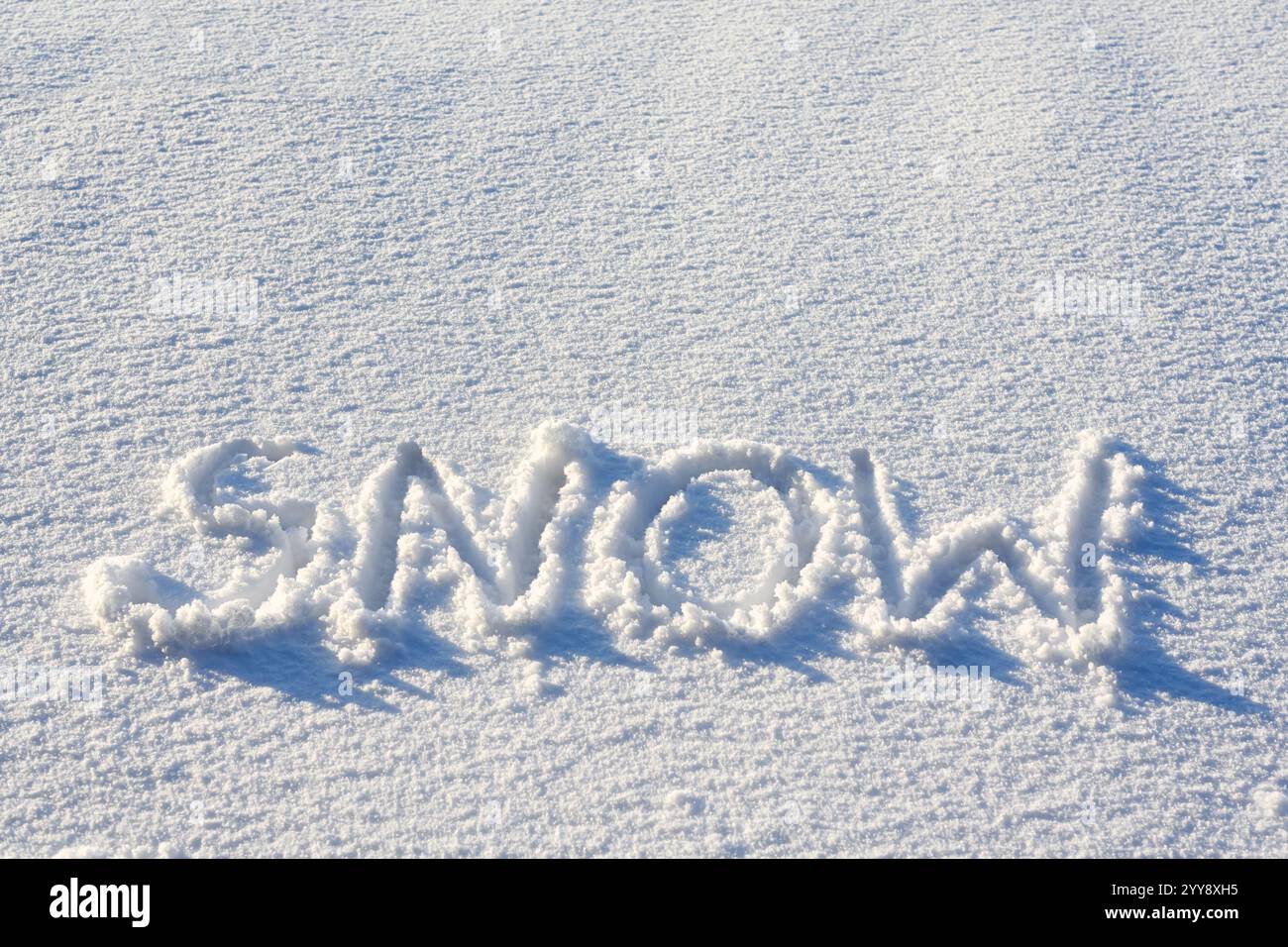 The word snow written on fresh snow in frosty sunny day. Can be used ...