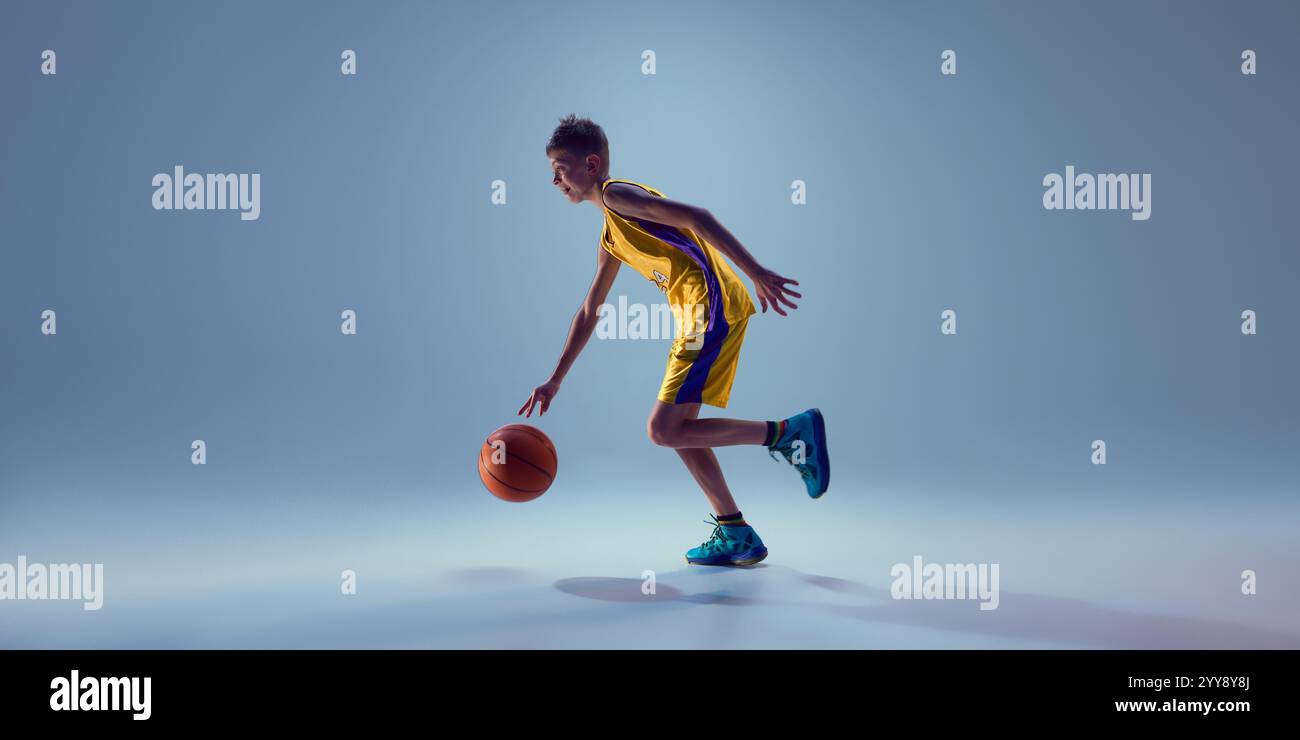Side view photo of junior basketball player training dribbling ...