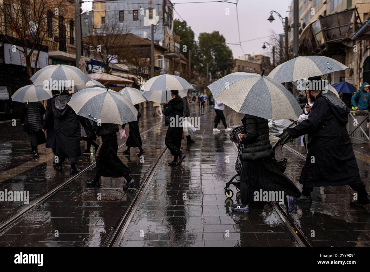 People walk with umbrellas on a rainy day in Jerusalem, Israel, Friday ...