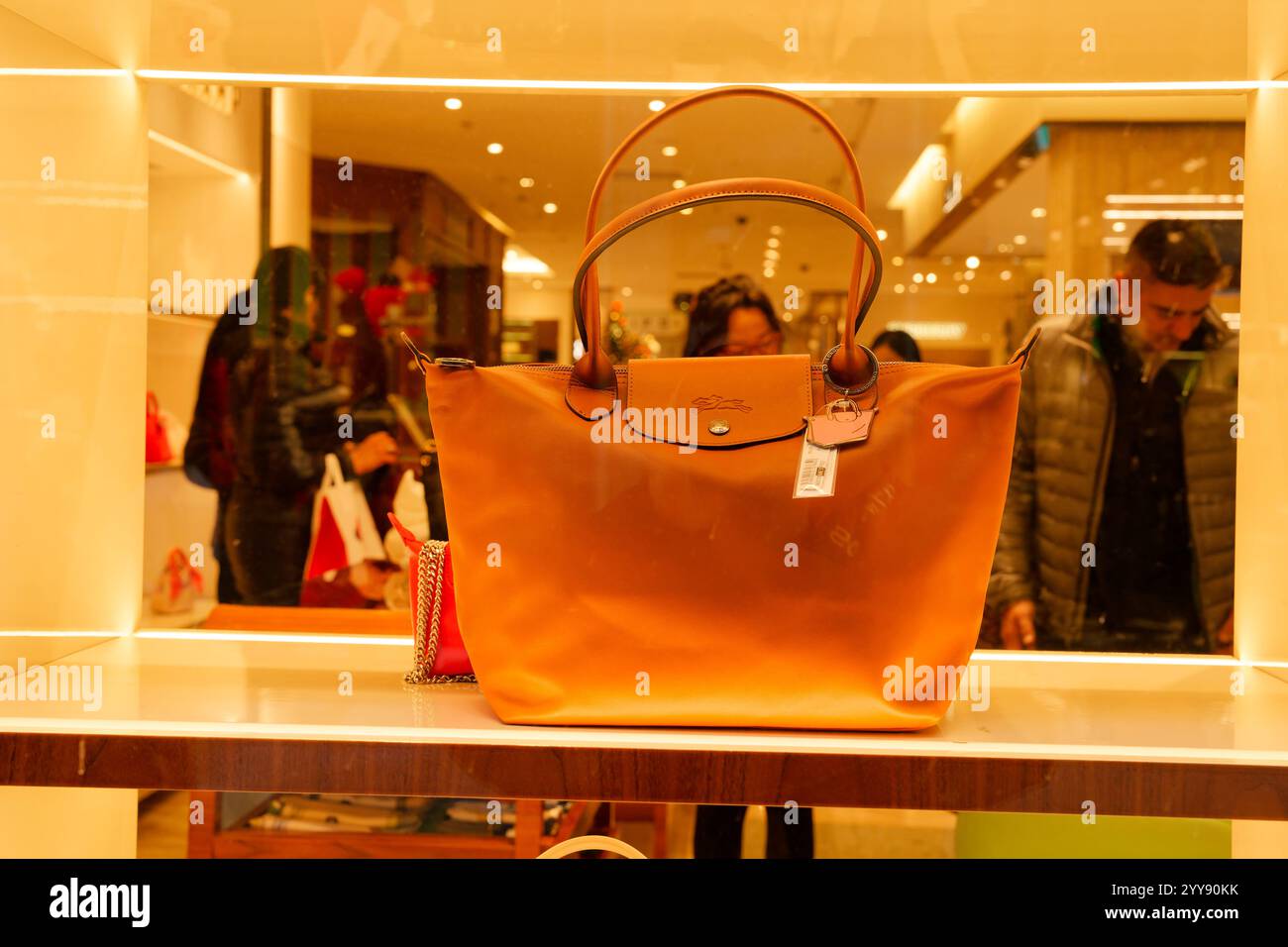 Bright yellow handbag displayed in a busy retail shop attracting ...