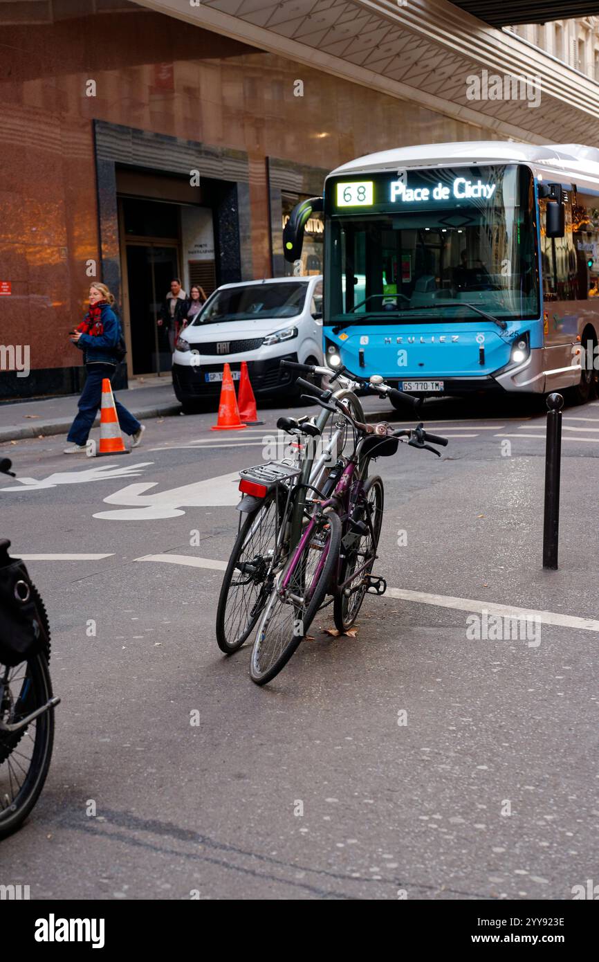 Busy urban street with parked bicycles and public transport at Place de ...