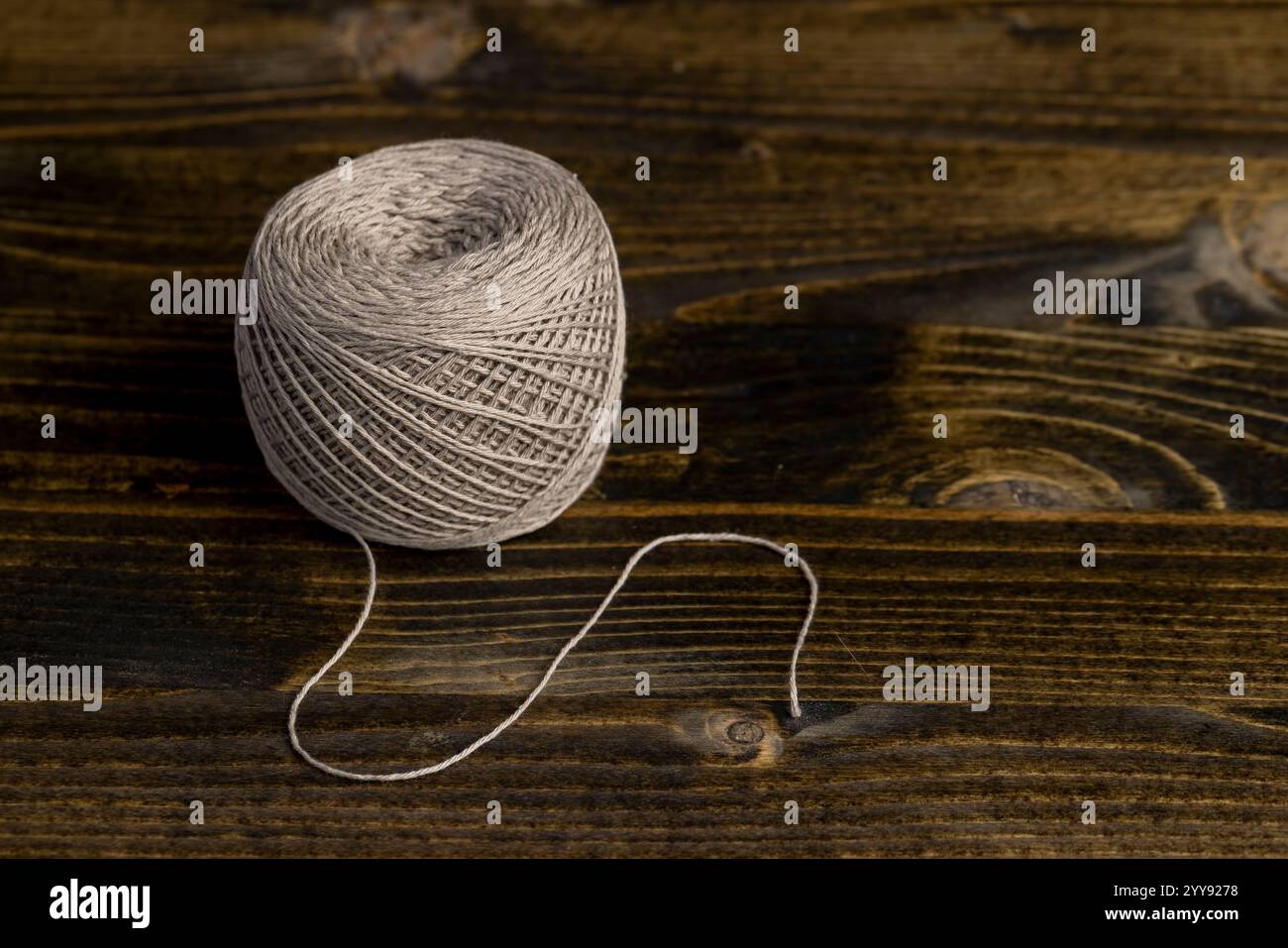 linen sewing threads in production, a new skein of grey thread is used ...