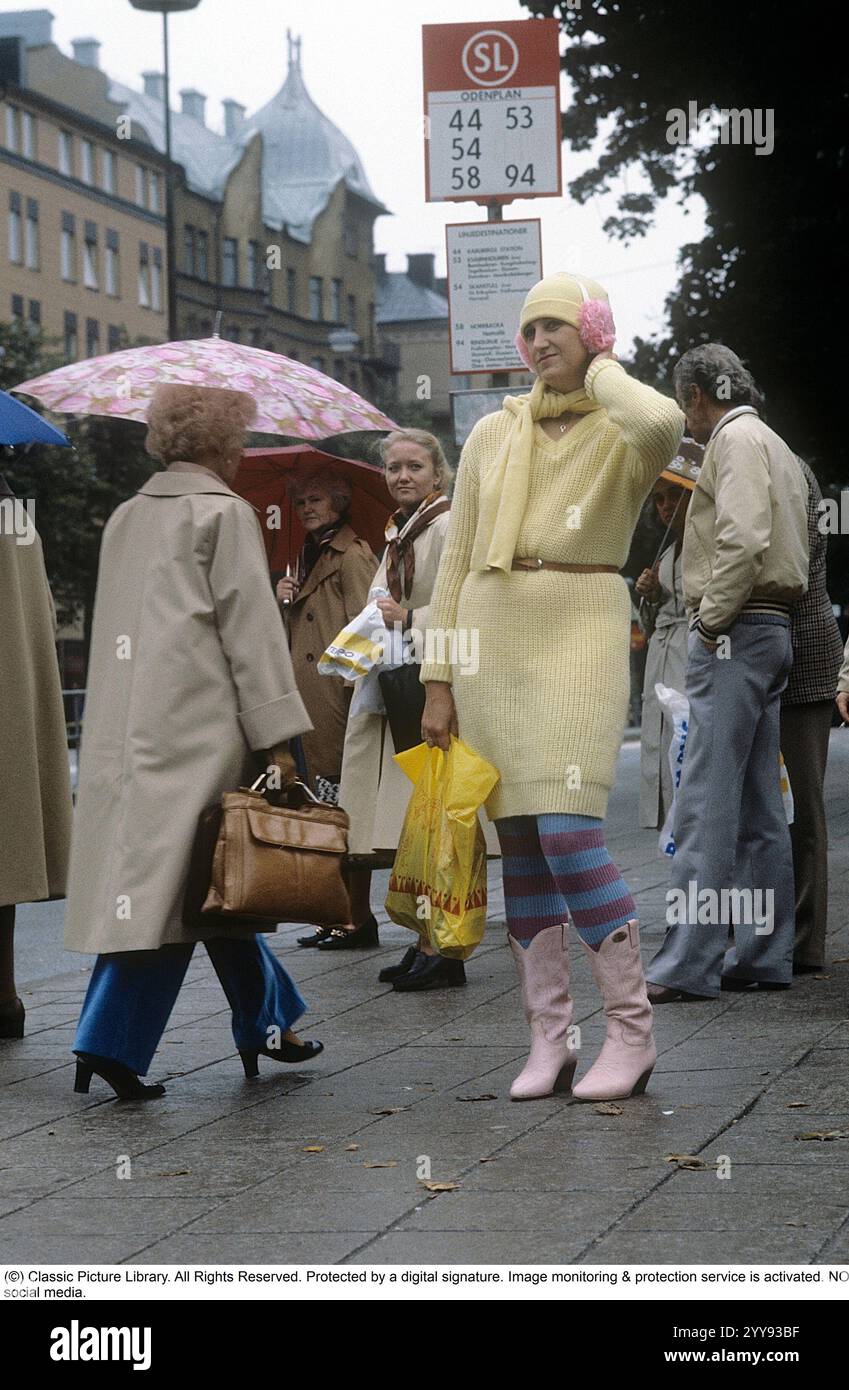 This is how people dressed in 1980. A woman is waiting for the bus at ...