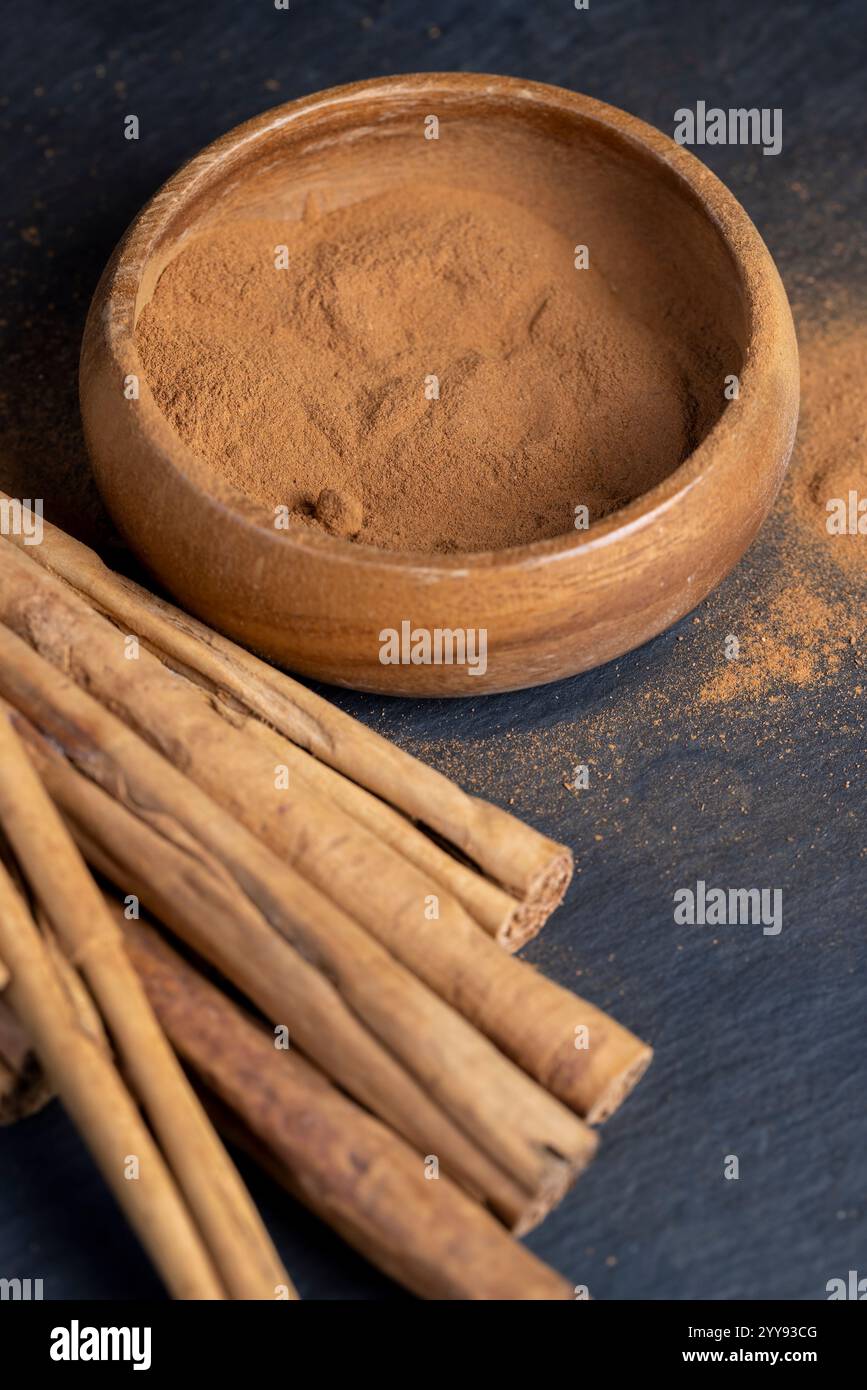 cinnamon tree bark with golden powder, ground and whole cinnamon used for making desserts Stock ...