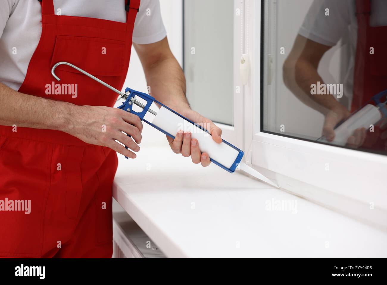 Worker with caulking gun sealing window indoors, closeup Stock Photo ...