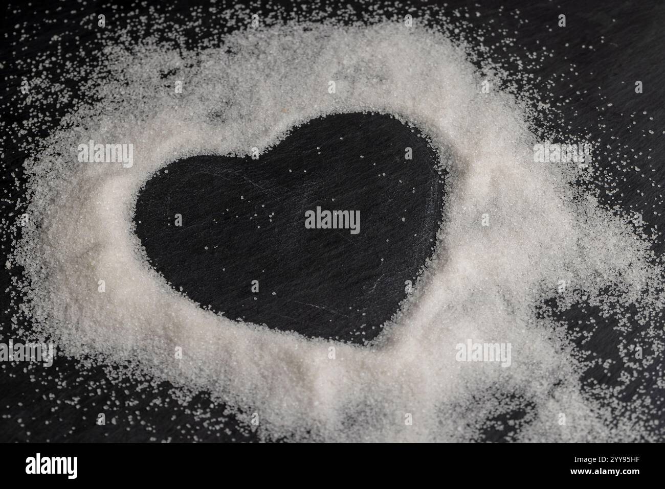 sugar from sugar beet, white granulated sugar on black slate, drawing ...
