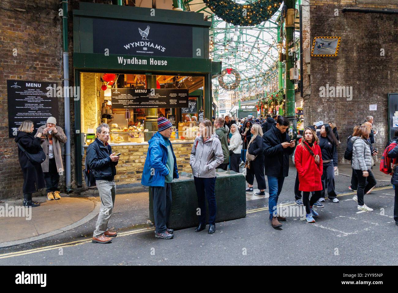 Shoppers in Borough market, a popular indoor food market in London, UK ...