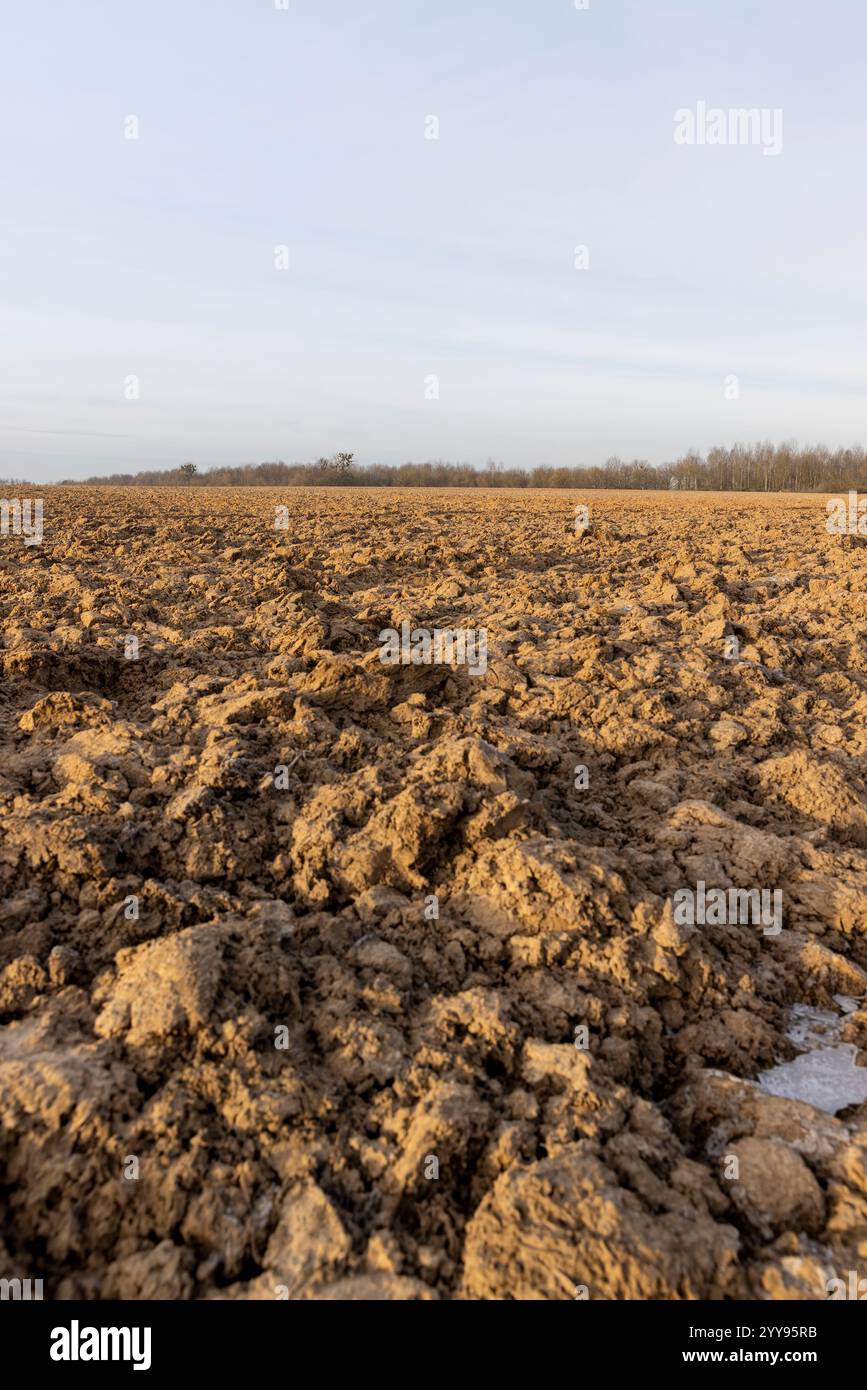 soil covered with snow and frost on the field, prepared for sowing a ...