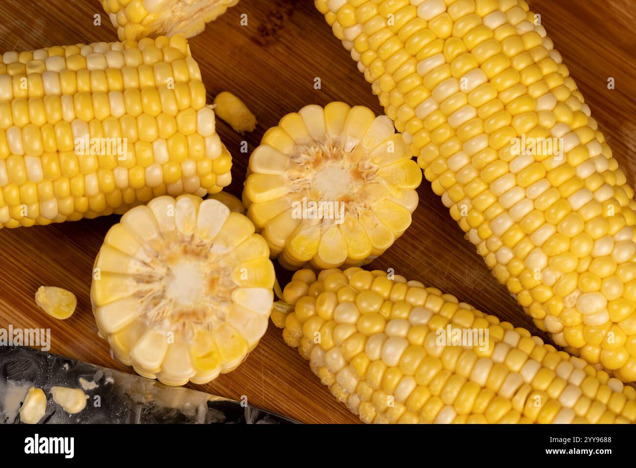 sliced peeled corn cob with yellow and white seeds of different sizes ...