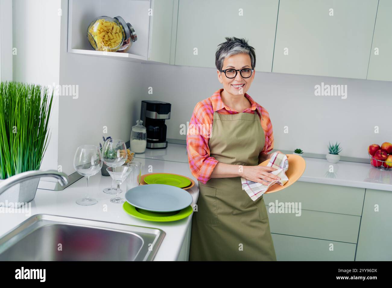 Charming woman enjoying casual cooking in modern kitchen with colorful ...