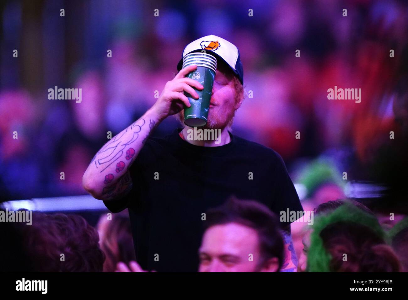 Singer songwriter Ed Sheeran drinks from a cup while being encouraged ...