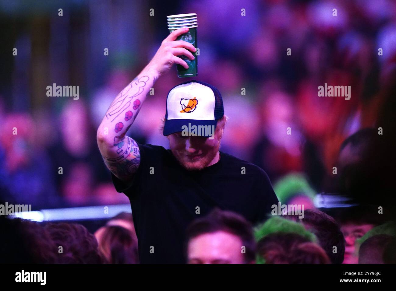 Singer songwriter Ed Sheeran drinks from a cup while being encouraged ...
