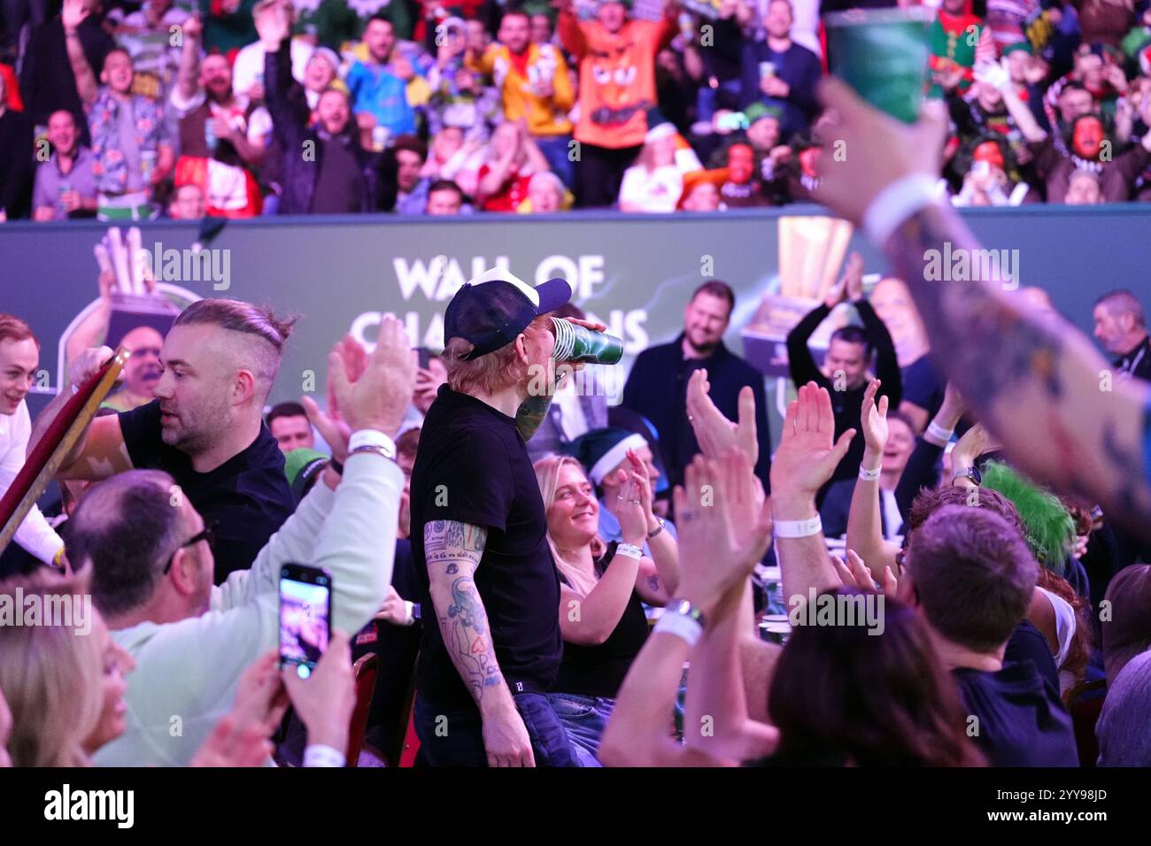 Singer songwriter Ed Sheeran drinks from a cup while being encouraged ...