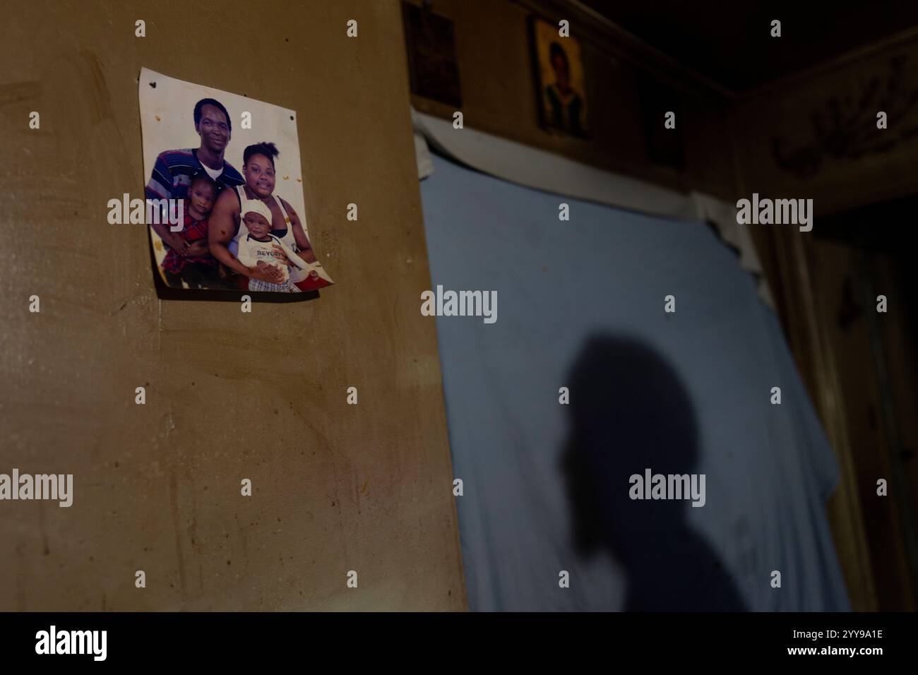 Tyrone Heard, shadow at right, looks at a photo of himself with his ...