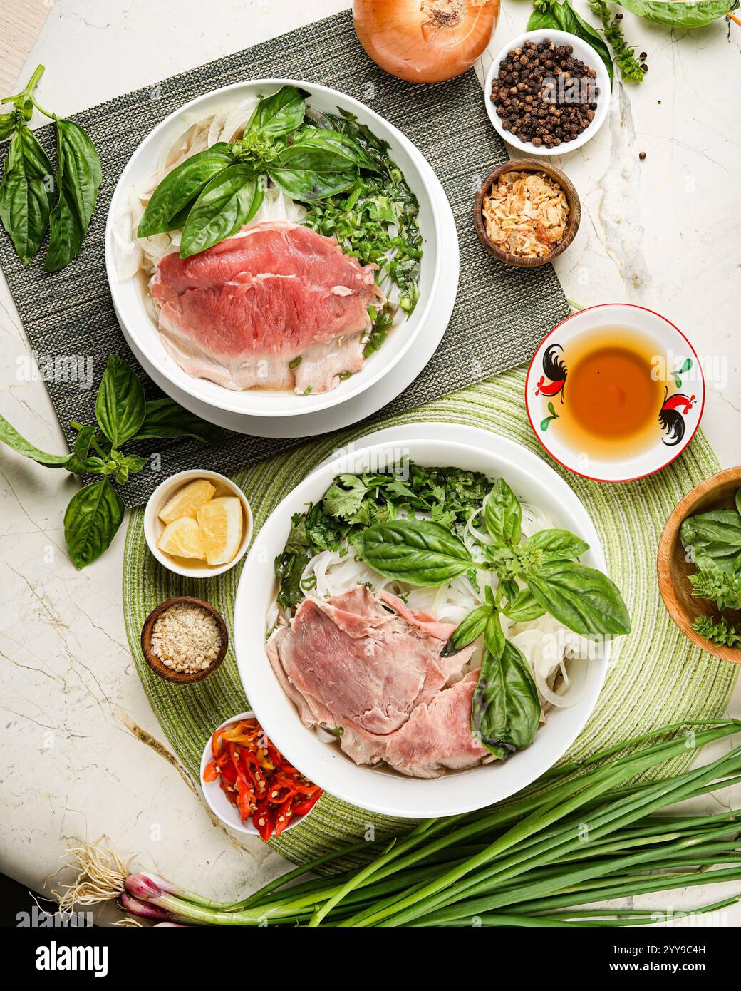 A bowl of authentic Vietnamese pho with rare beef, fresh basil, onions ...