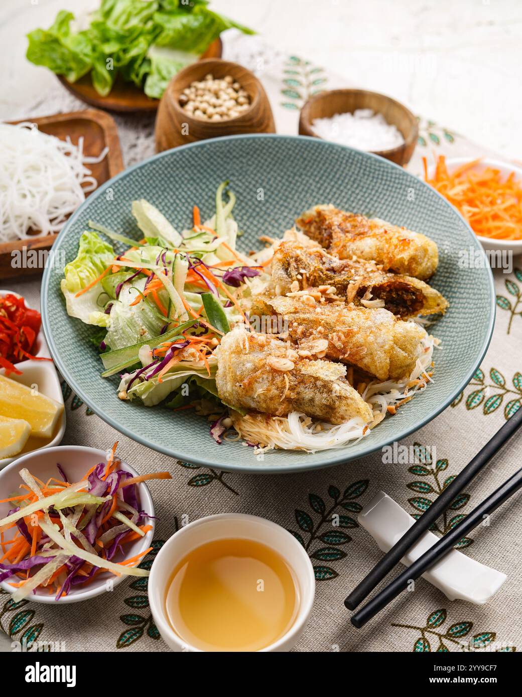 A vibrant Vietnamese dish of crispy fried spring rolls over delicate ...