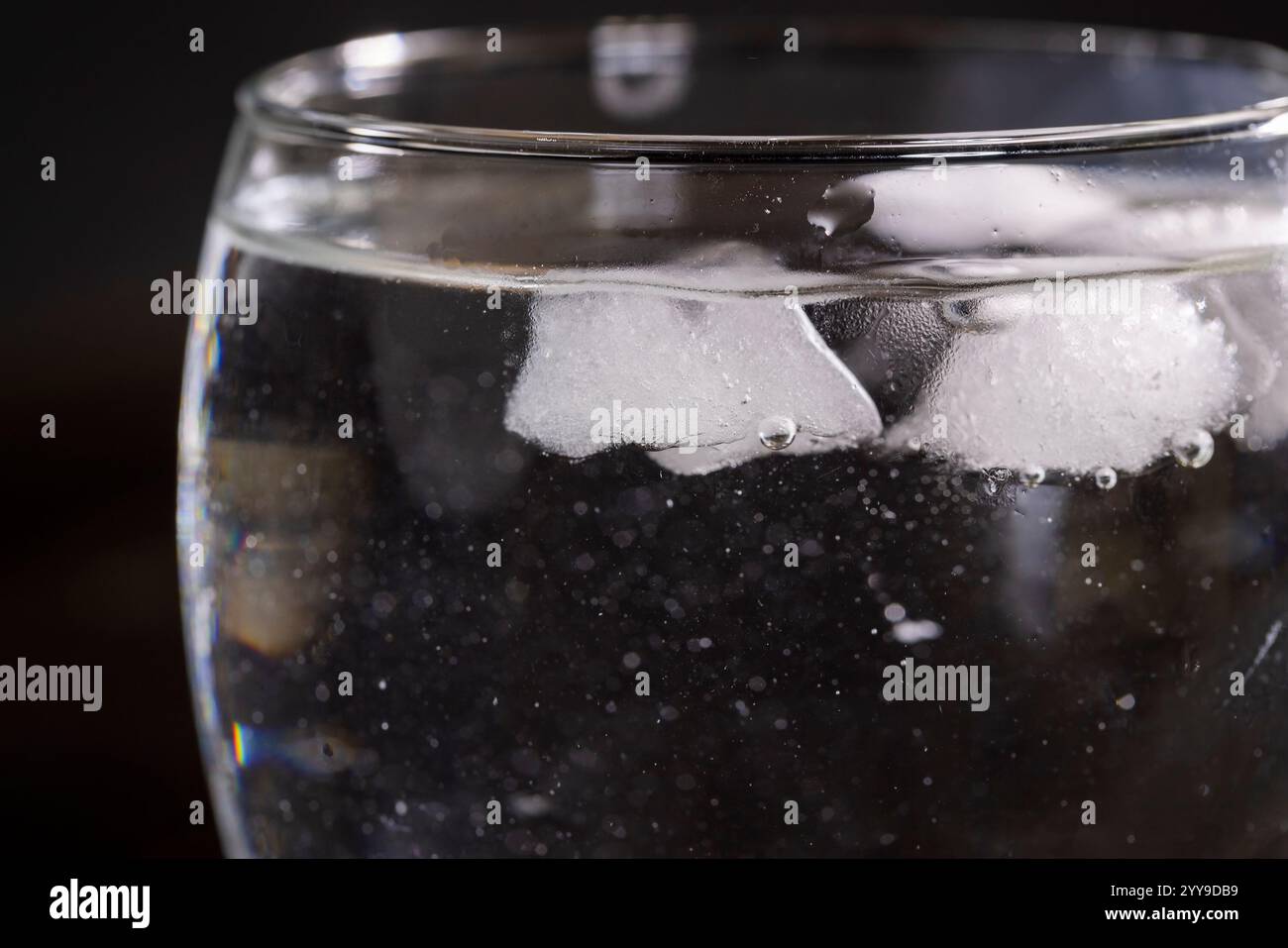 glass with cold sparkling water close up, cold mineral water with a lot of gases and bubbles ...