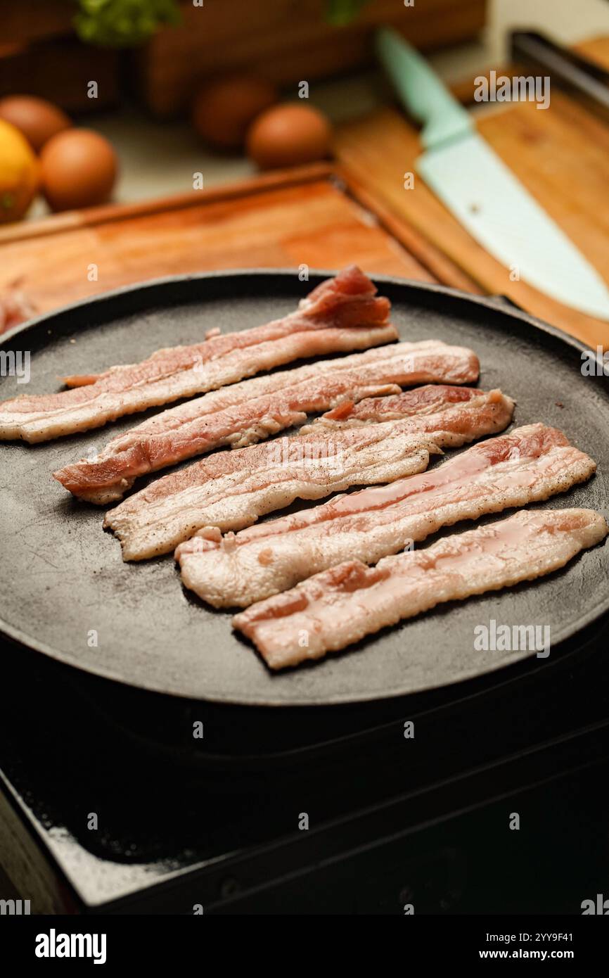 Sizzling pork belly slices cooking on a hot griddle—crispy edges, juicy ...