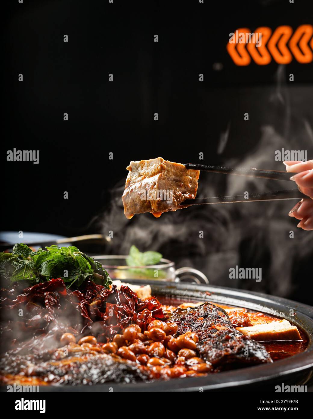 A feast of bold flavors—spicy grilled fish stew bubbling with chilies ...