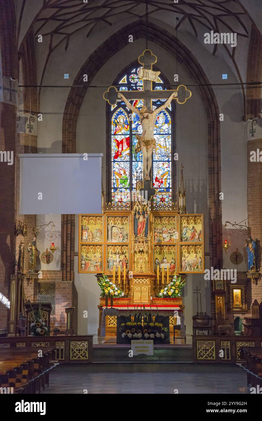 Gothic altar in a church, decorated with a crucifix and stained glass ...