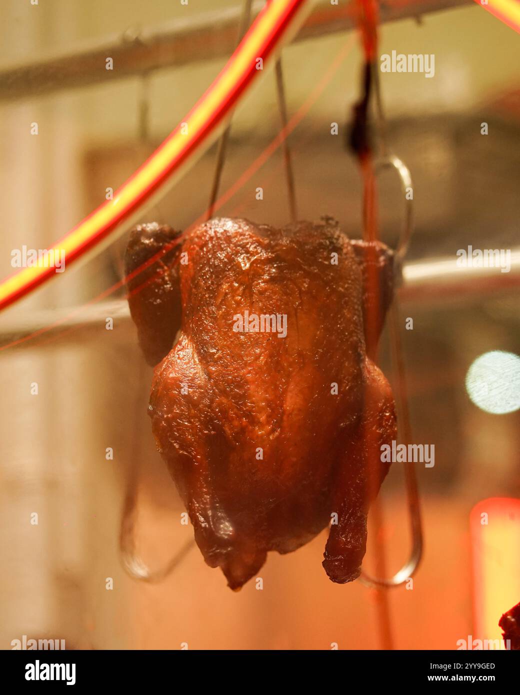 A whole roasted duck hanging in a display window at a Chinese BBQ ...
