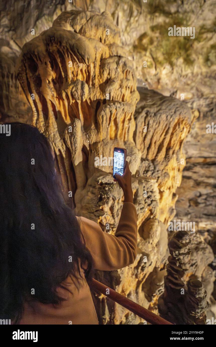 Tourist taking pictures of large stalactites inside postojna cave, a ...