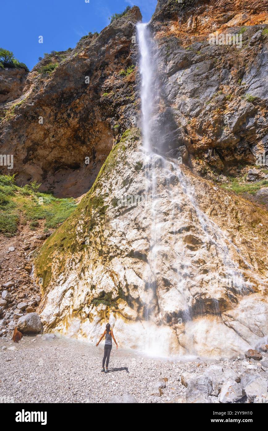 Female hiker enjoying the refreshing spray of rinka waterfall in the ...