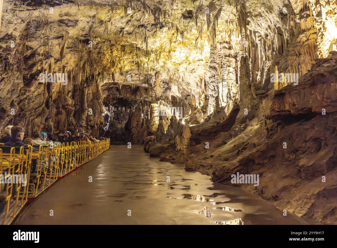 Tourists visiting the magnificent postojna cave in slovenia, riding an ...